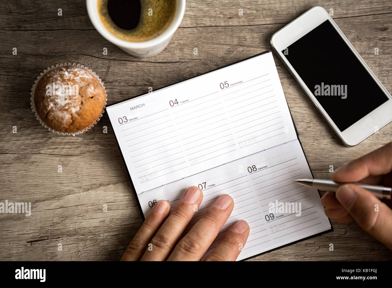 male hand writing at planning notebook on wooden desk Stock Photo - Alamy