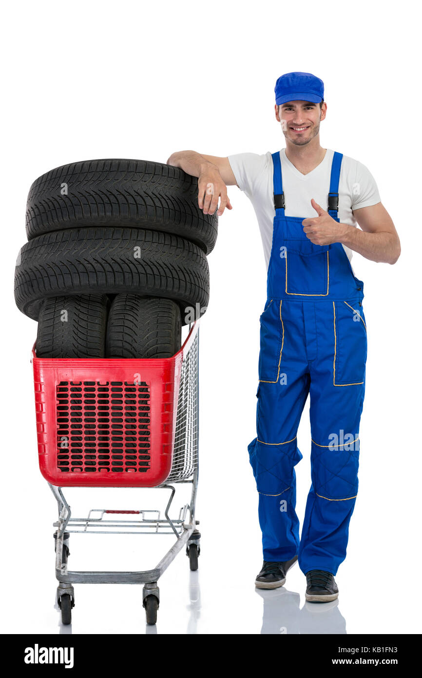 smiling young mechanic with tires giving a thumbs up Stock Photo - Alamy