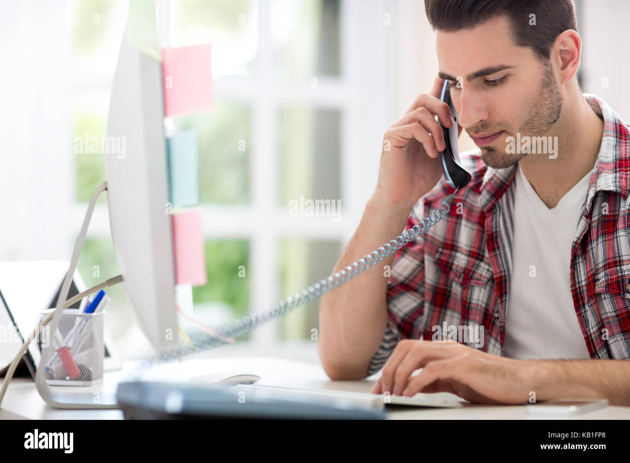Busy man in office sitting at desk, back view Stock Photo - Alamy
