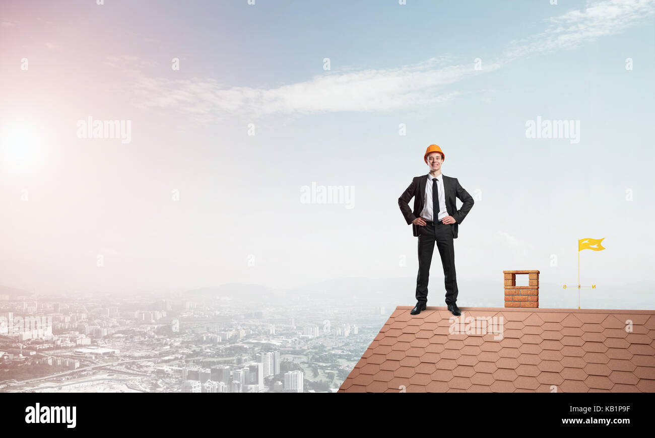 Engineer man standing on roof and looking away. Mixed media Stock Photo ...