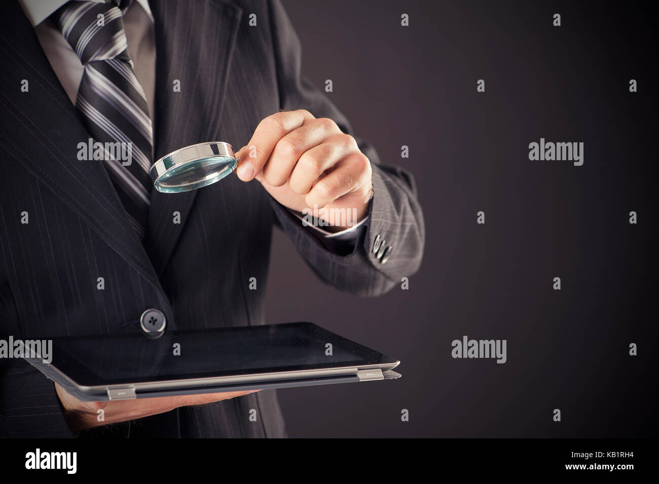 Businessman holding magnifying glass and digital tablet concept Stock ...