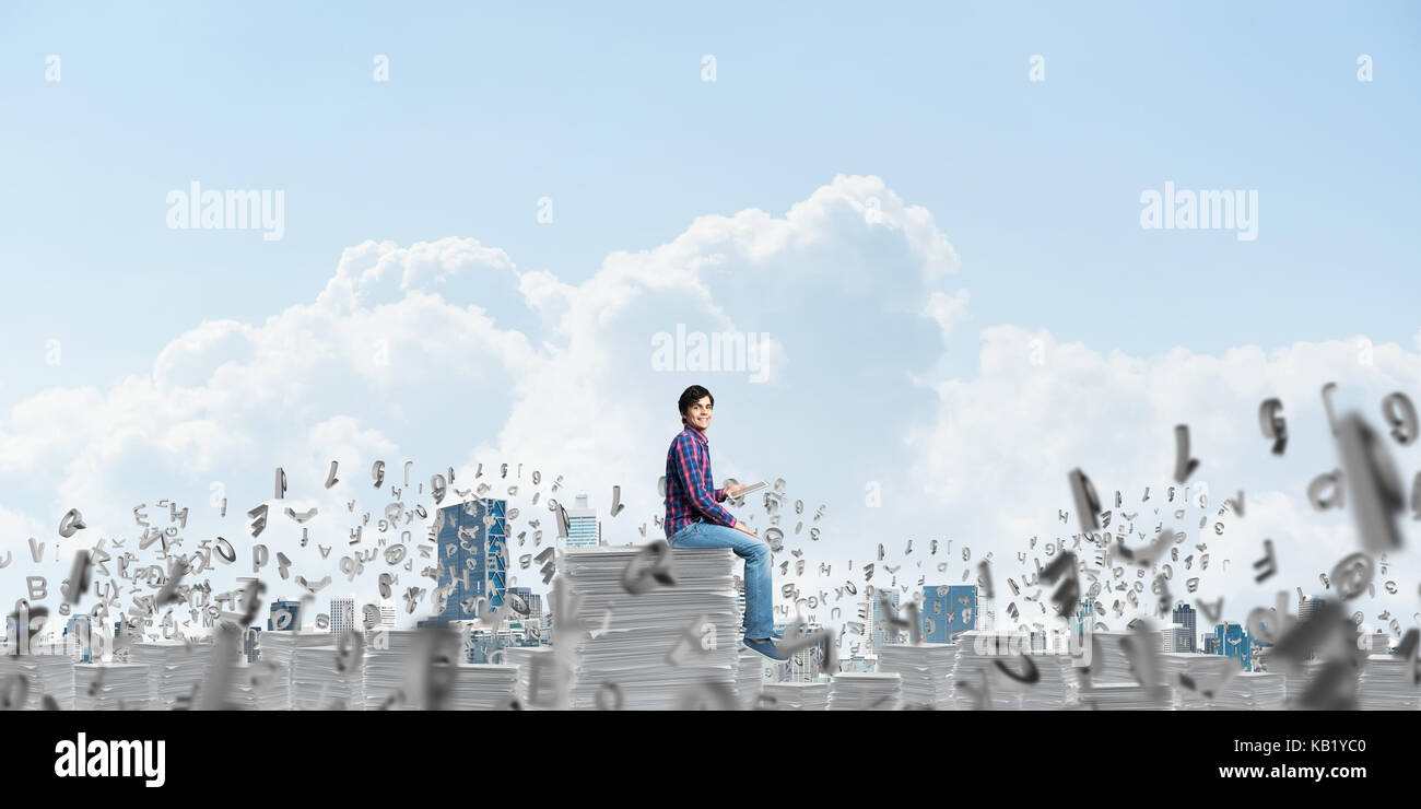 Attractive man sitting on pile of paper documents Stock Photo - Alamy