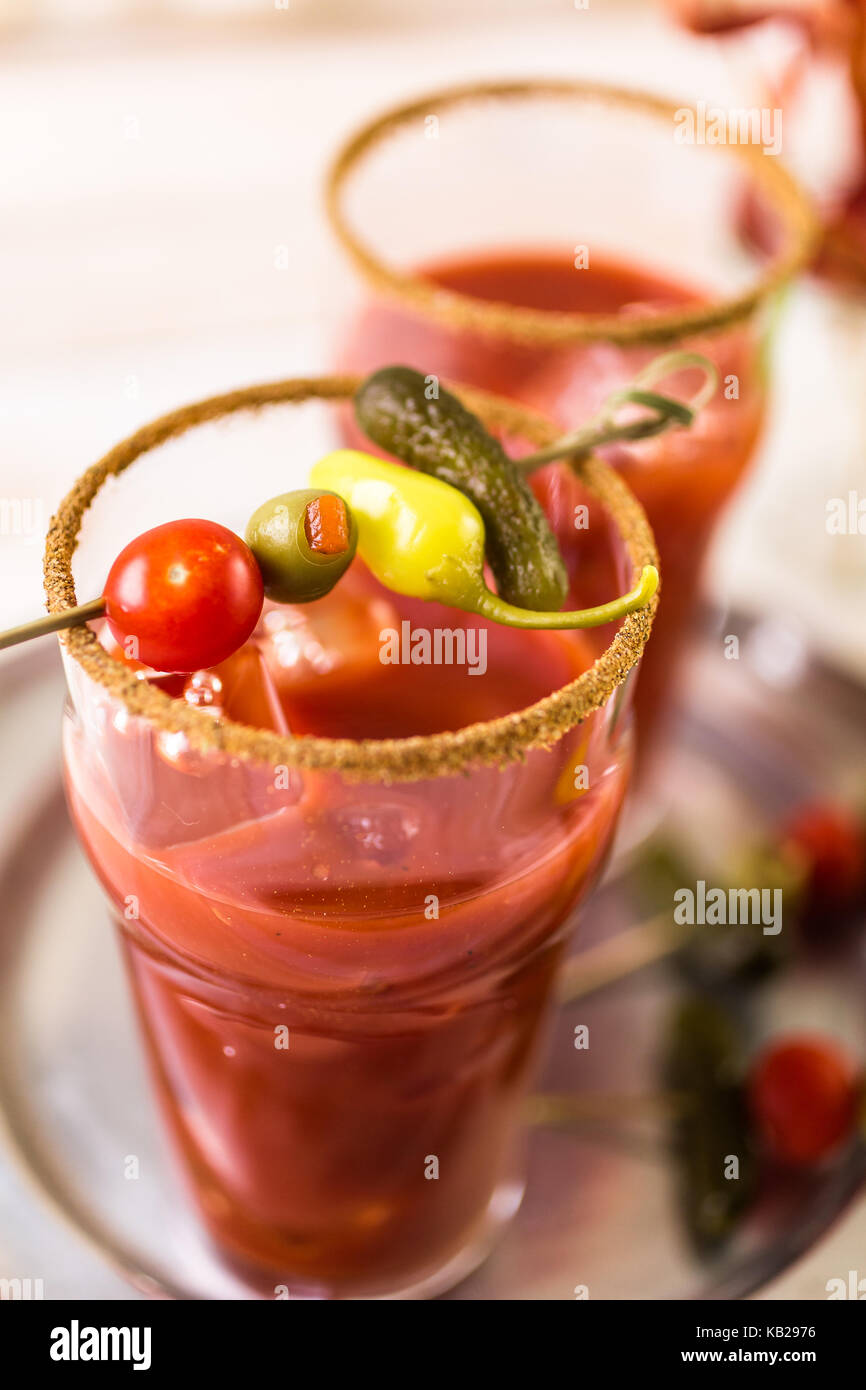 Bloody mary cocktail garnished with celery sticks, olives, and bacon ...