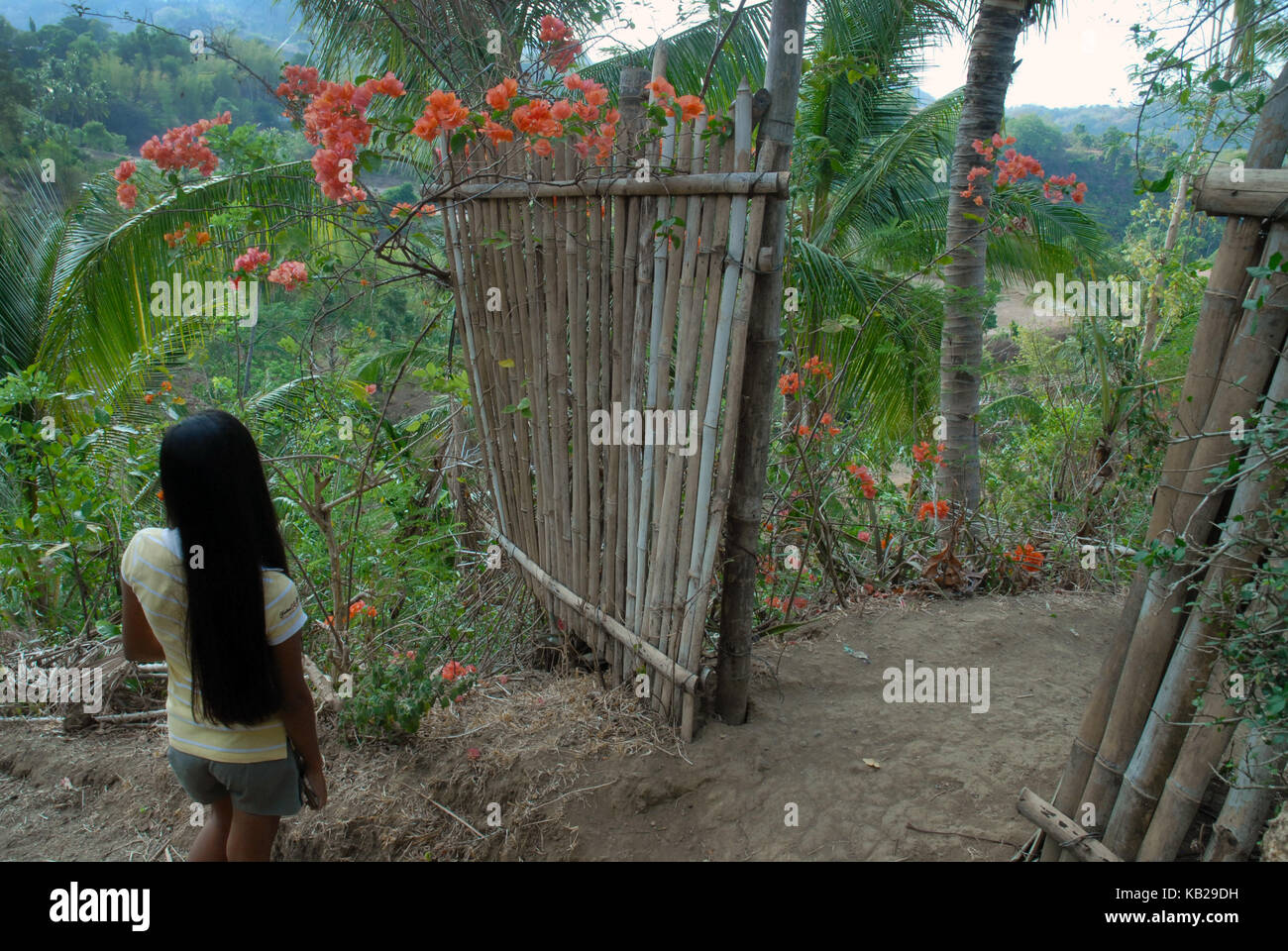 Young girl standing outside her front gate, Mabini Sur, San Joaquin ...