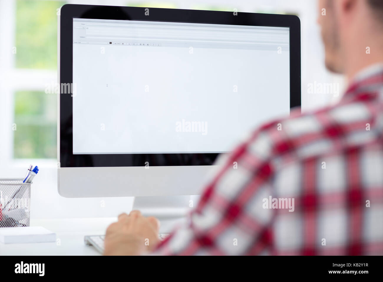 Portrait from behind of young man using computer Stock Photo - Alamy