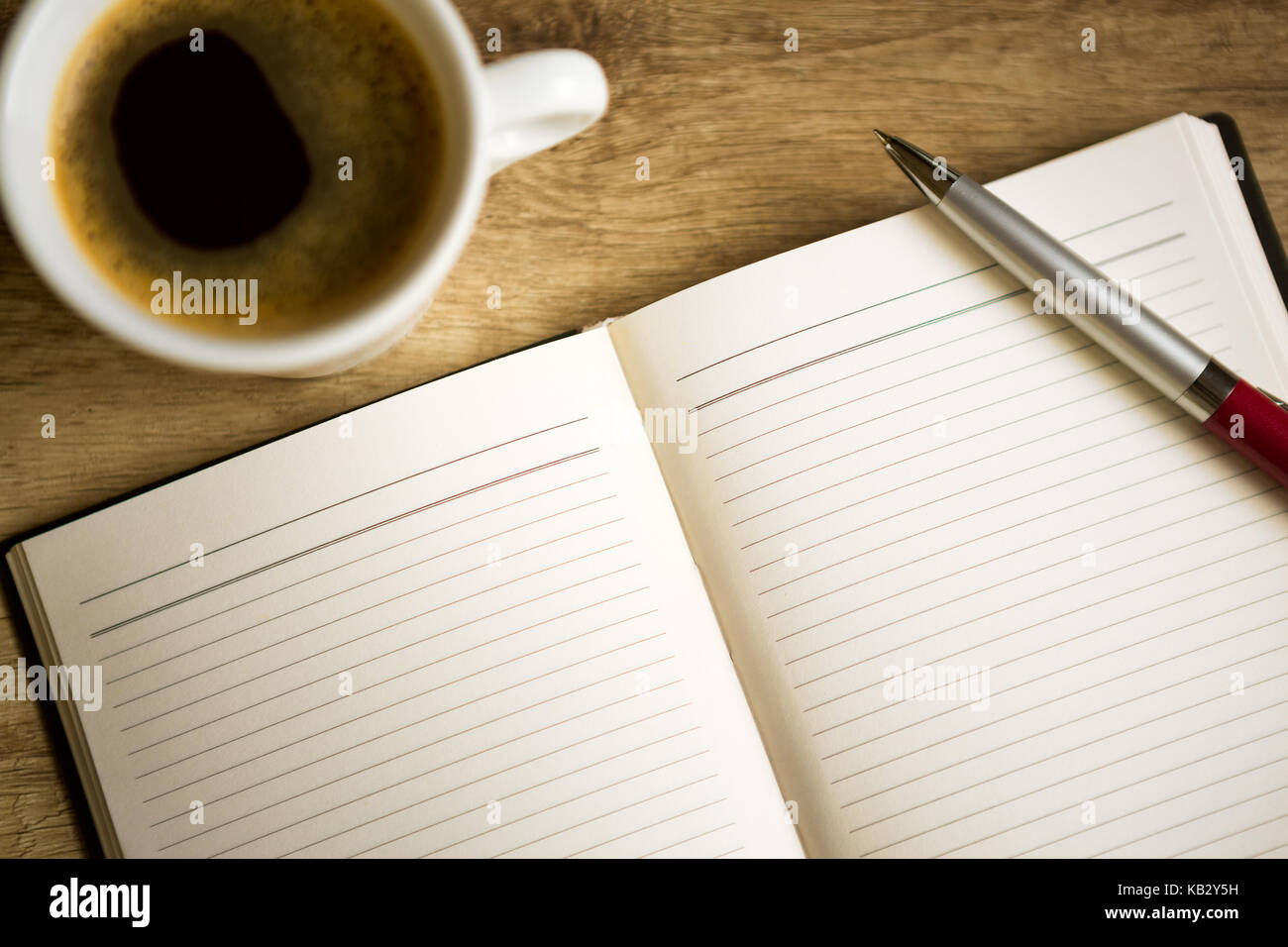 Notebook with coffee cup on wooden table, top view Stock Photo - Alamy