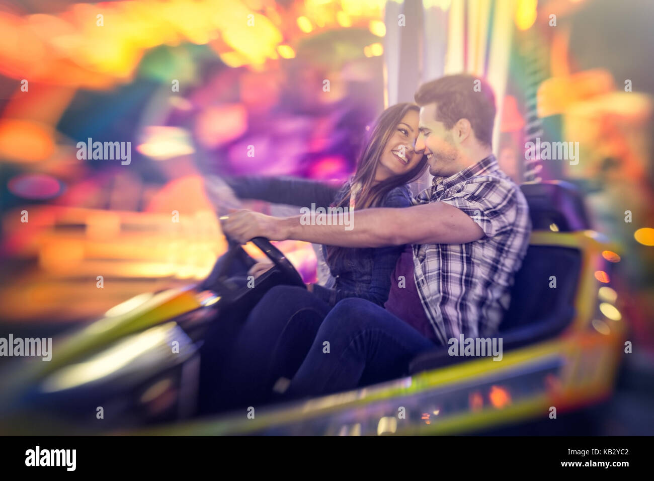Happy couple ride bumper car on a fun fair amusement Stock Photo - Alamy