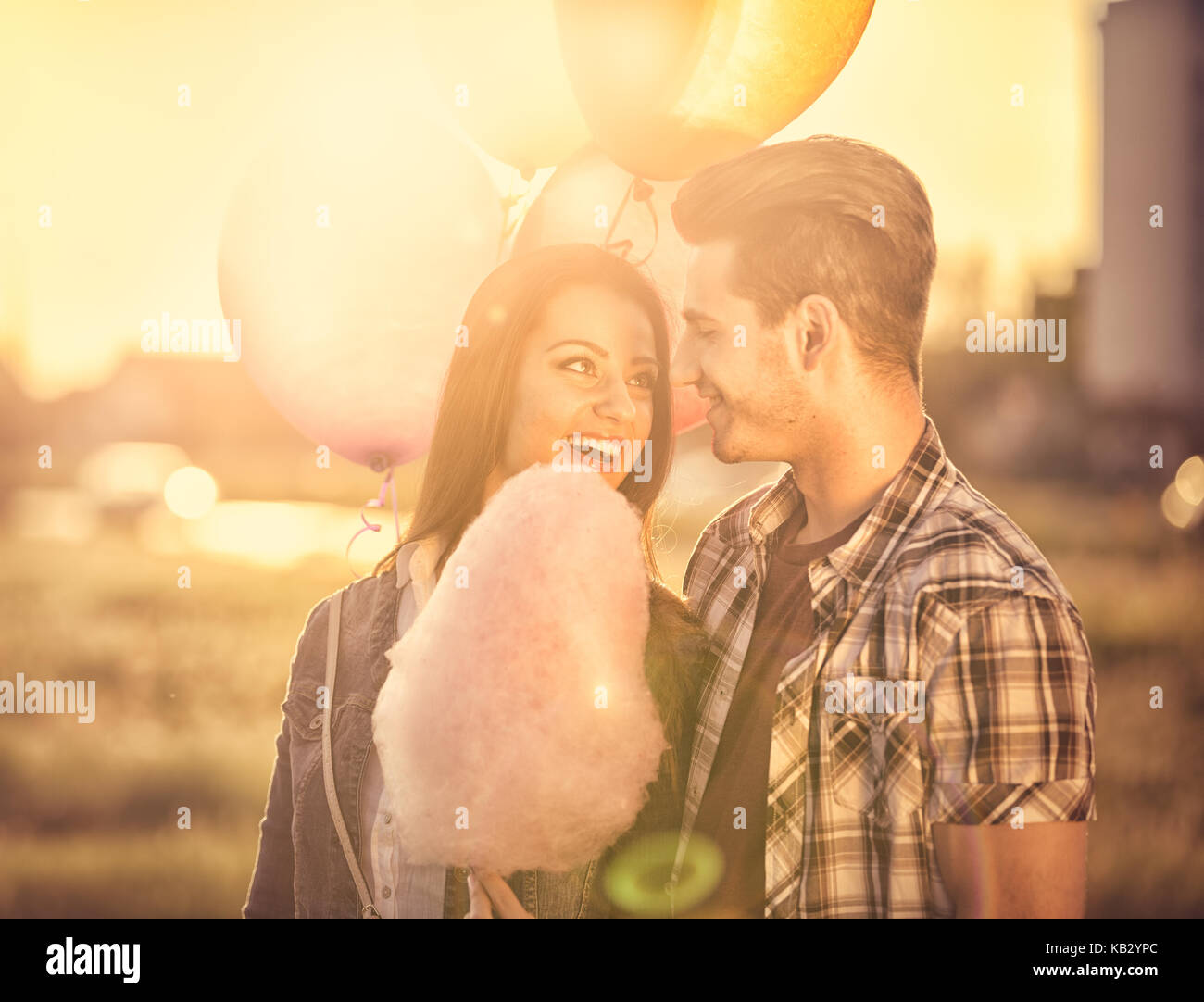 smiling young couple in love with cotton candy in amusement park Stock ...
