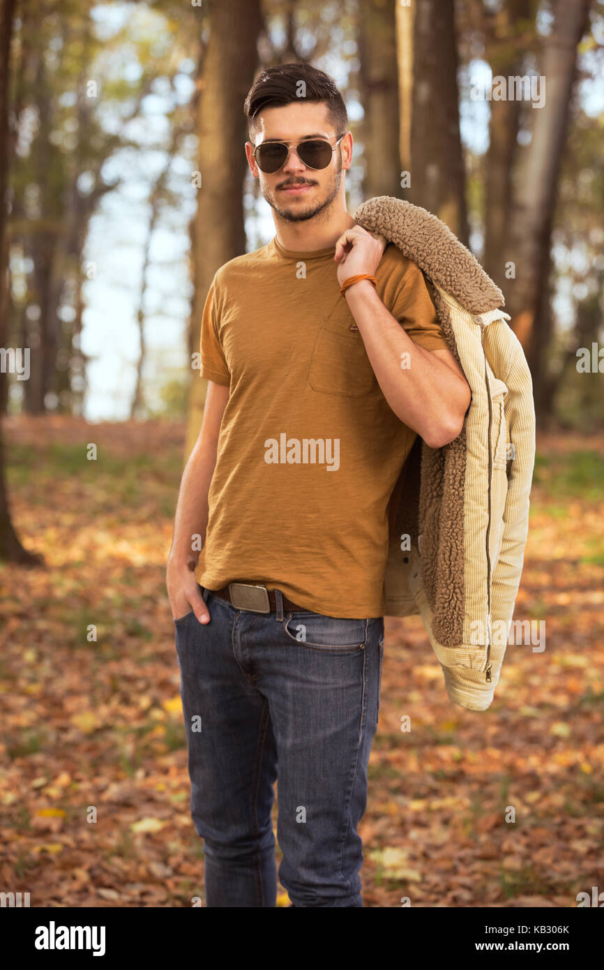 Trendy men holding jacket over shoulder Stock Photo - Alamy