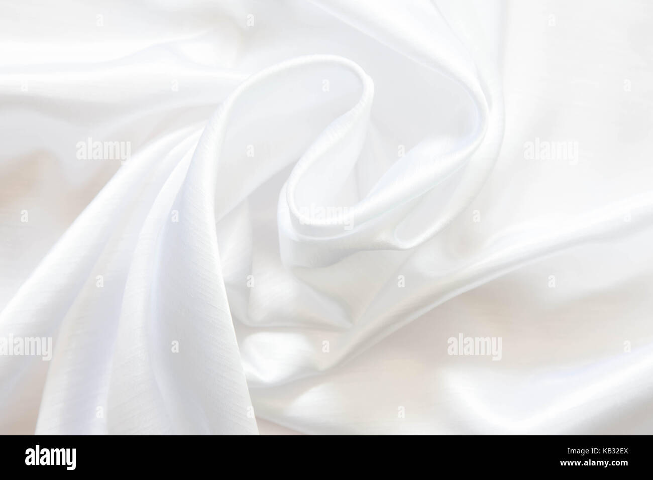 White shiny silk folded with soft folds. Matte and glossy white fabric ...