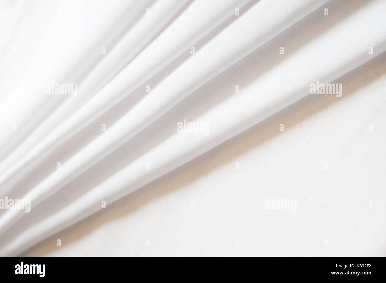 White shiny silk folded with soft folds. Matte and glossy white fabric ...