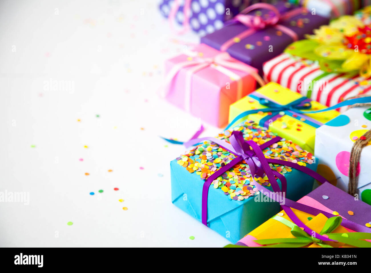 Colored gift boxes with colorful ribbons. White background. Gifts for ...