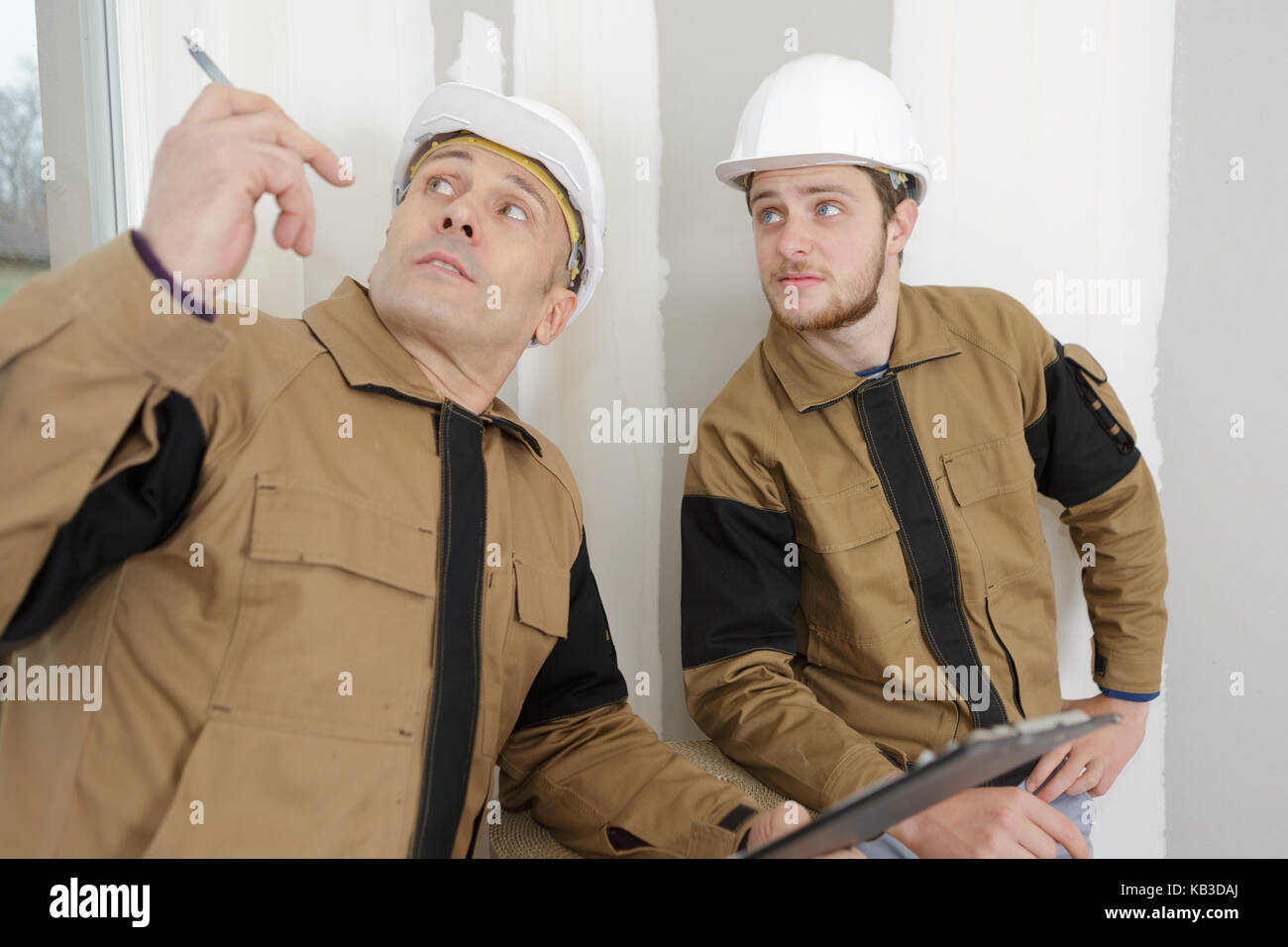 mason manager giving instructions to a helper Stock Photo - Alamy