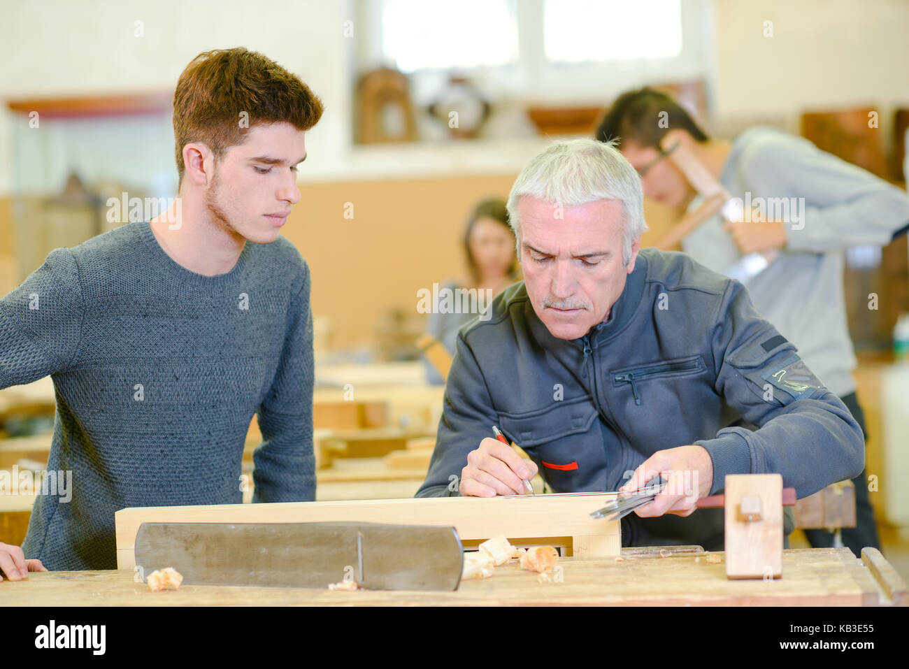 carpenter with apprentice in training period Stock Photo - Alamy