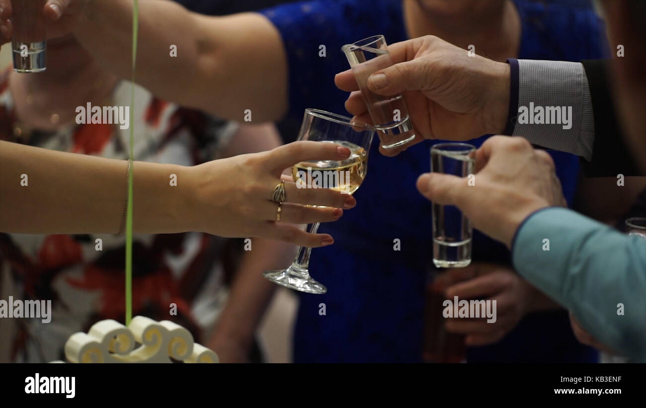 Peaople on the party or wedding cheers with shot glasses. Friends ...