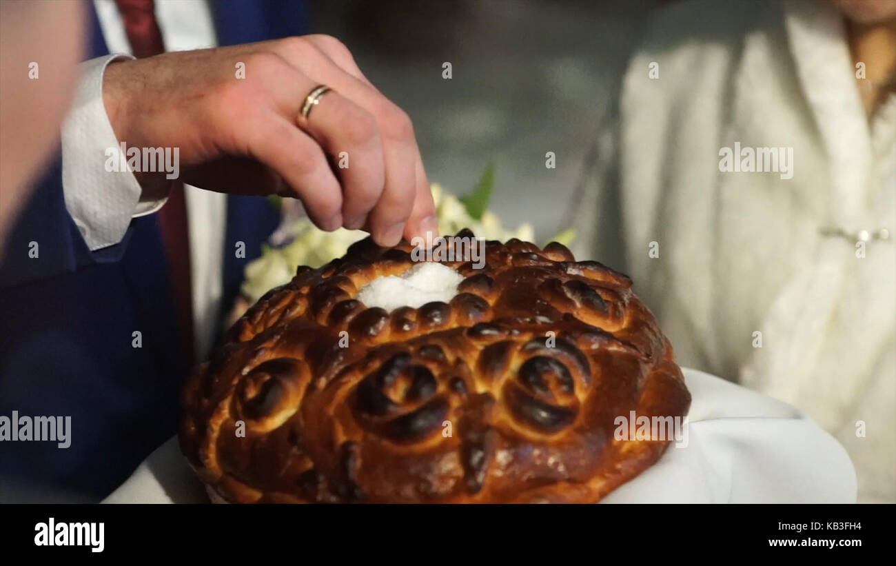 Bread and sault at the Wedding. The groom sprinkles the bread with salt ...