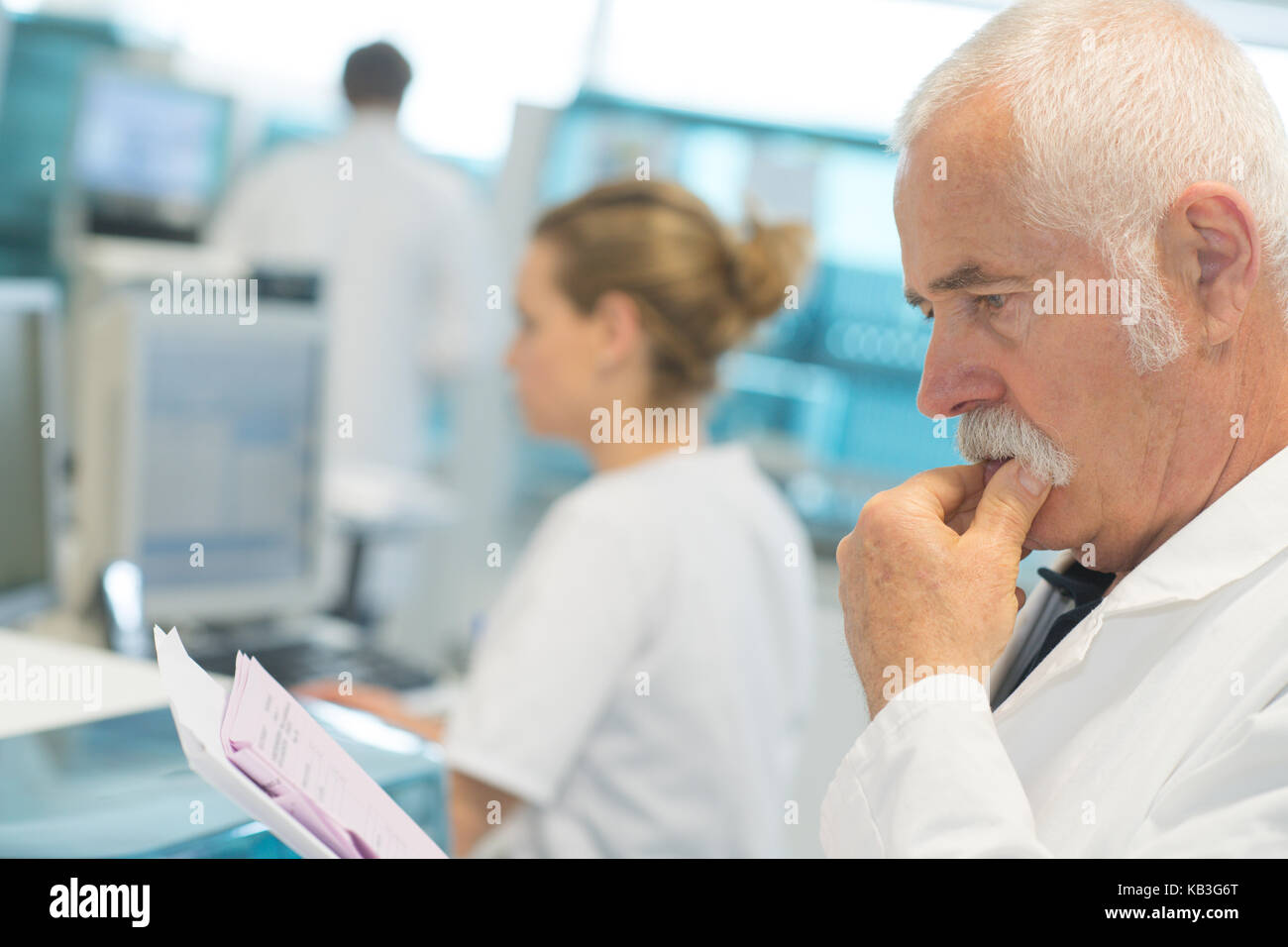 male medicine doctor reading document on clipboard Stock Photo - Alamy