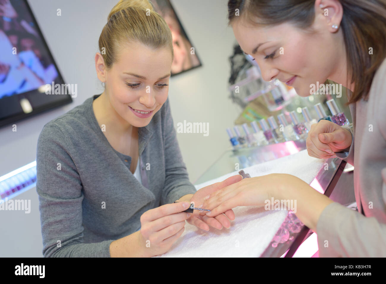 attractive nail salon worker giving a manicure her regular customer ...