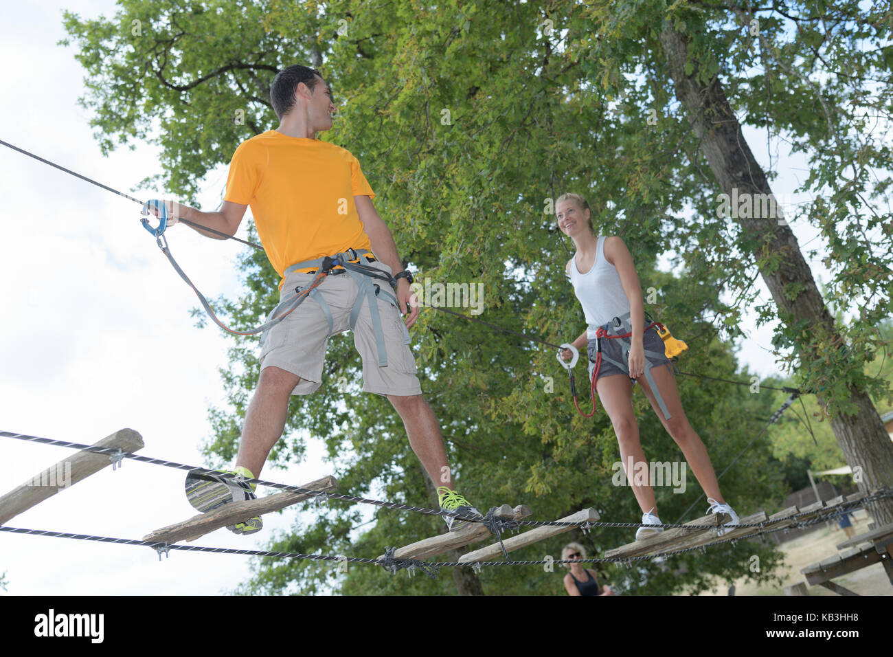 visitors in adventure park clambering with ropes Stock Photo - Alamy