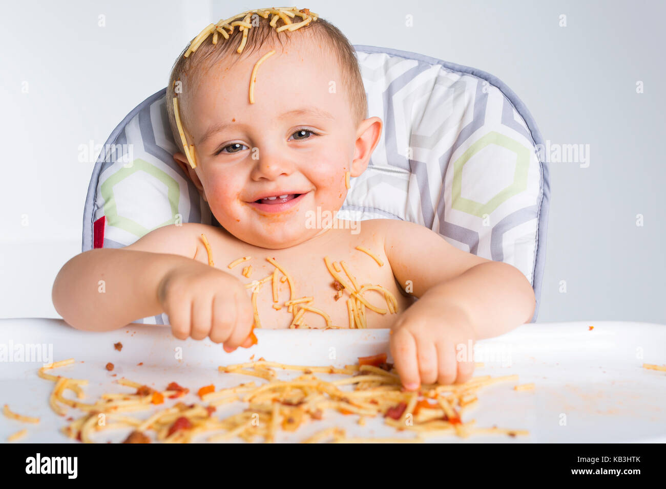 Little baby eating her dinner and making a mess Stock Photo - Alamy