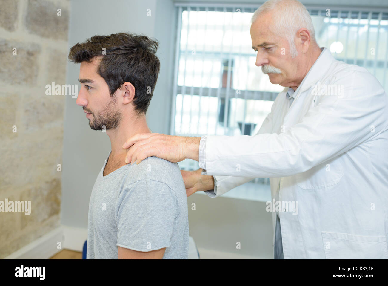 male chiropractor doing neck adjustment in a rehabilitation center ...