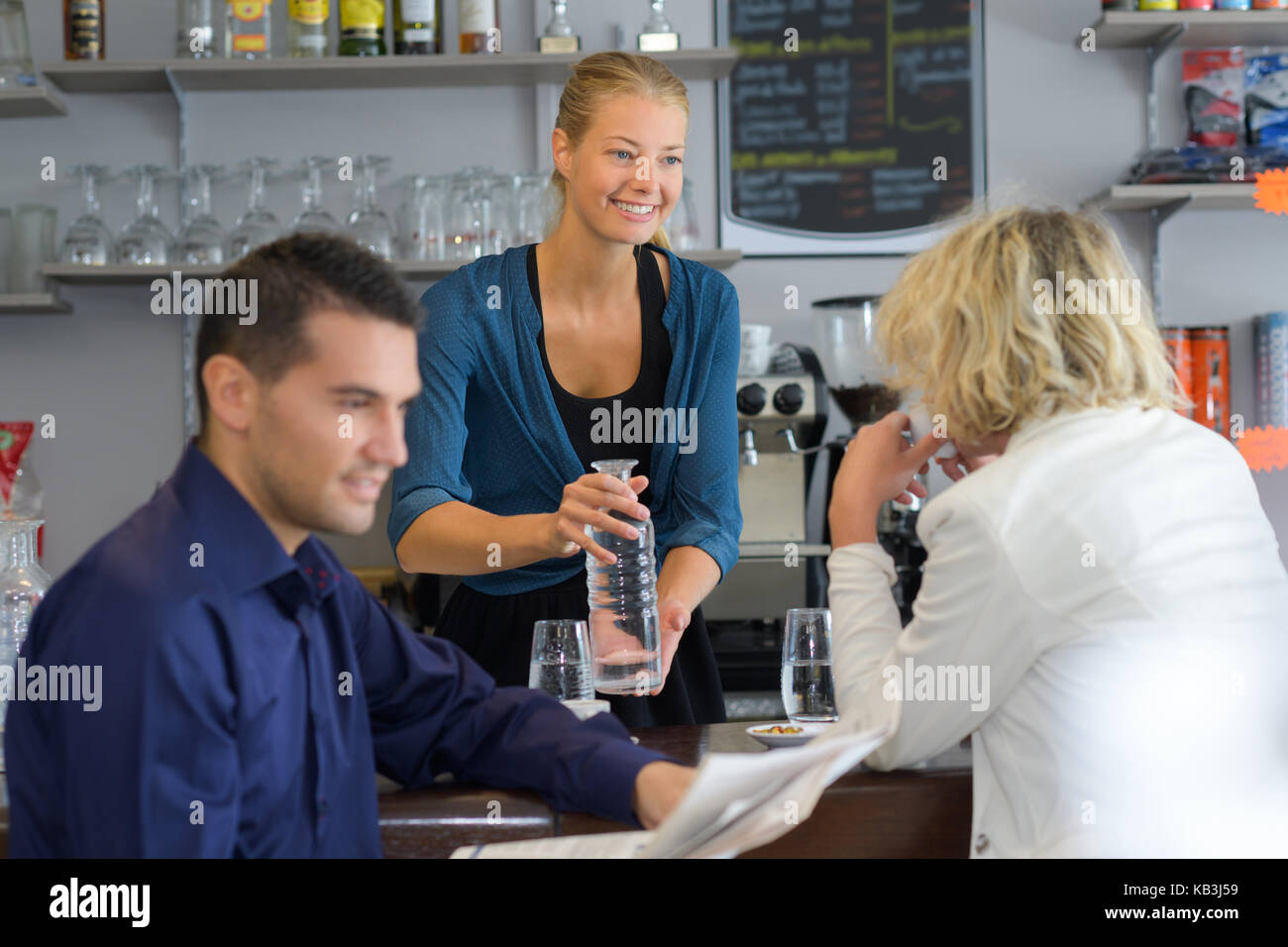 happy young barmaid serving drinks Stock Photo - Alamy
