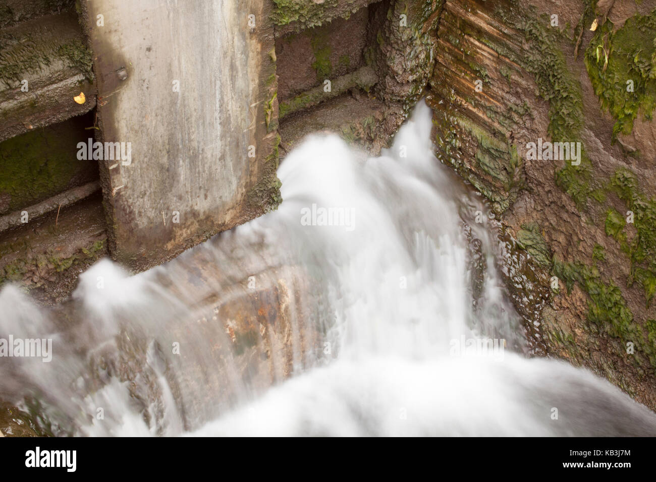 Stream blurred water in small waterfall in dam Stock Photo - Alamy