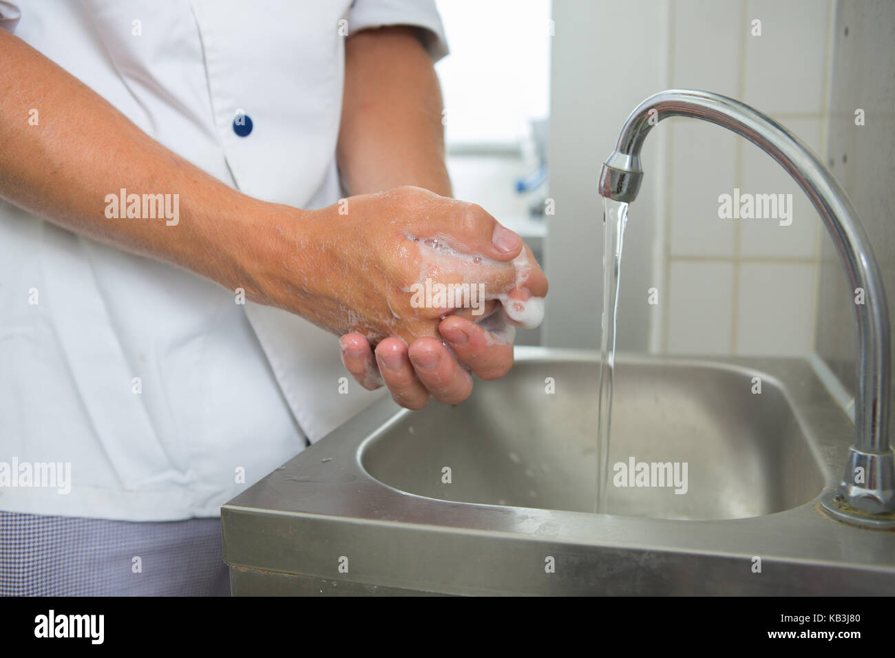 man washing hands in kitchen Stock Photo - Alamy