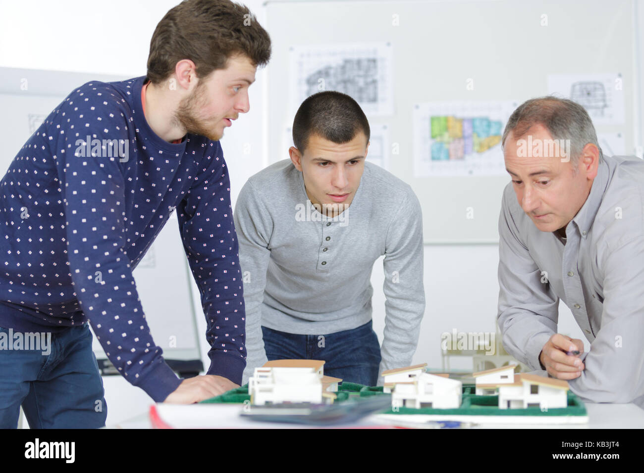 smiling architects with house model and blueprint working in office ...