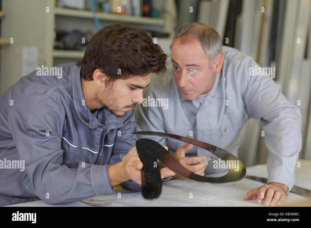 engineer checking trainees work on factory floor Stock Photo - Alamy