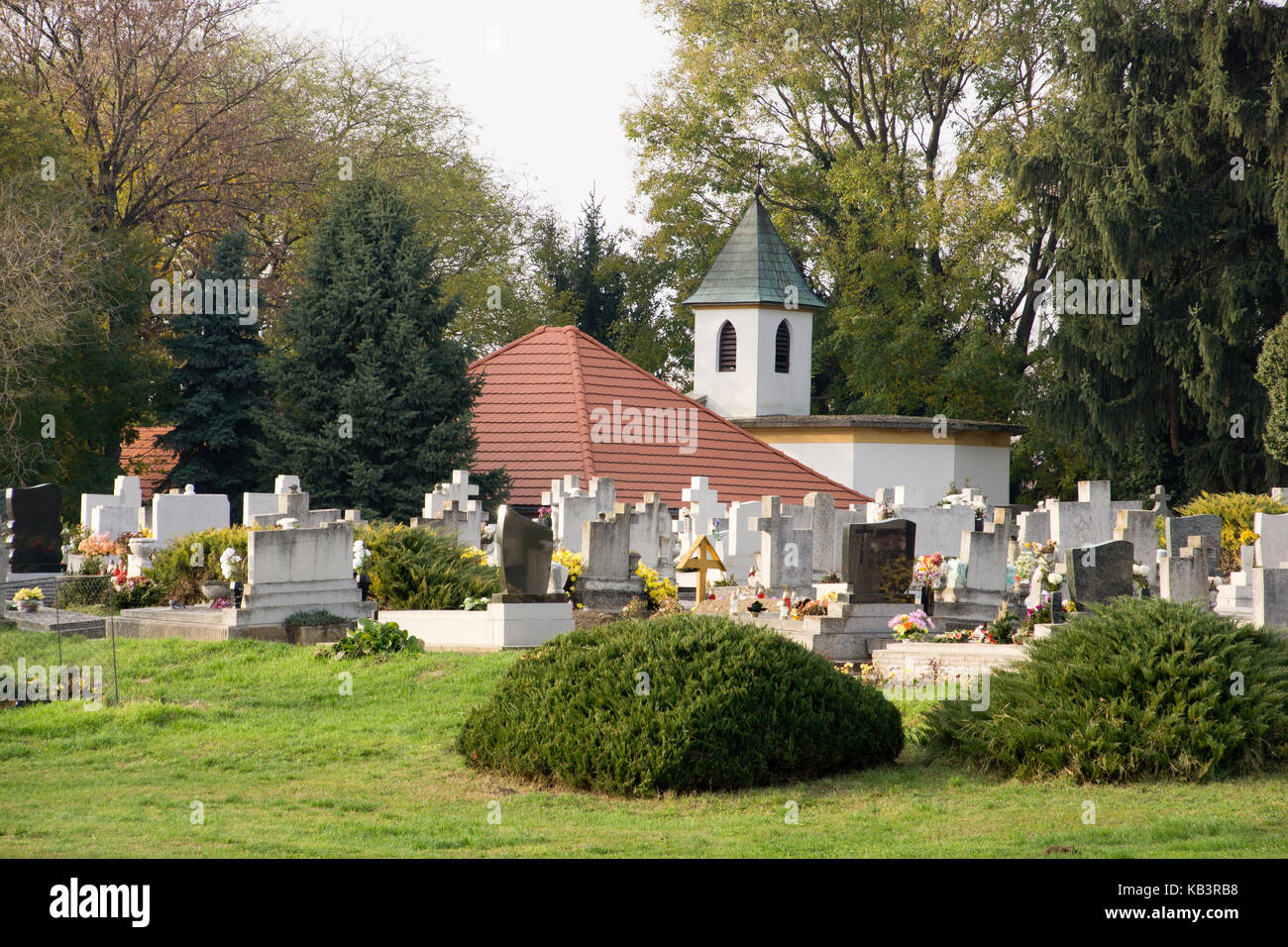 Hungarian cemetery with lots of flowers and crosses and a small chapel ...