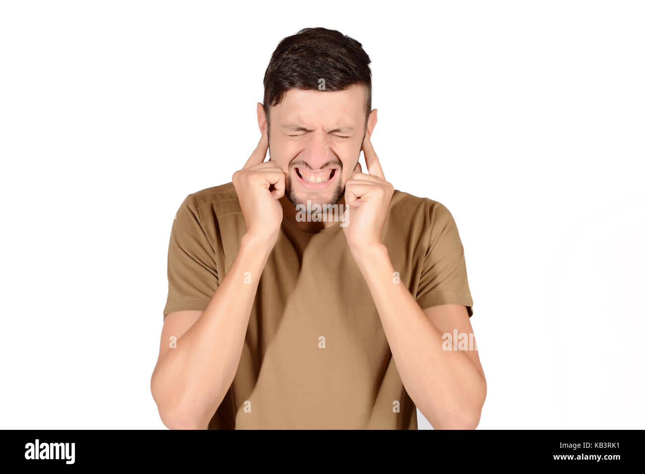 Portrait of a young man covering his ears. Isolated white background ...