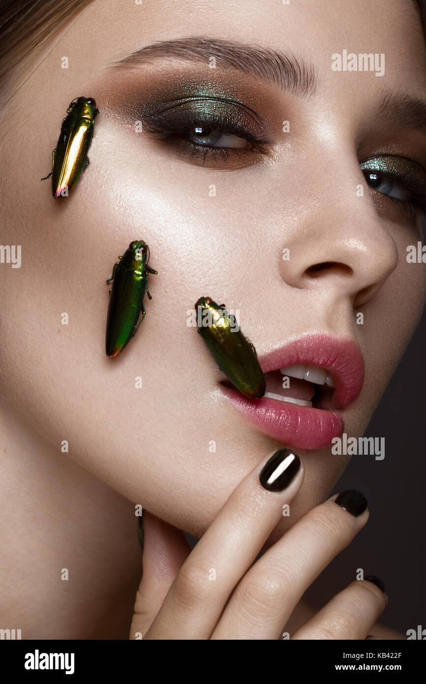 Portrait of beautiful girl with colorful make-up and cockroaches ...