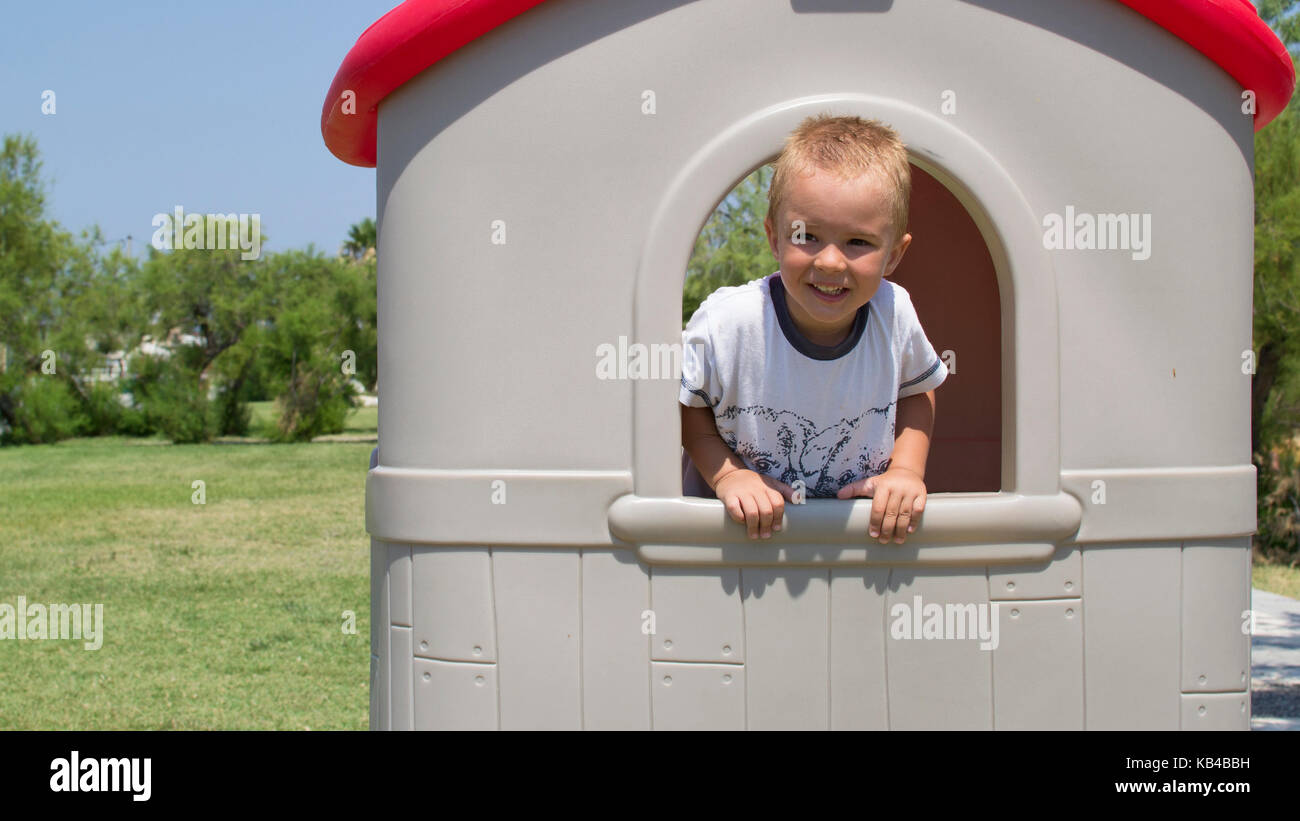 Cute little boy in toy house smiling Stock Photo - Alamy