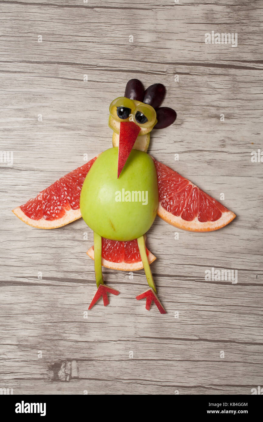 Sad rooster made with fruits on wooden background Stock Photo - Alamy
