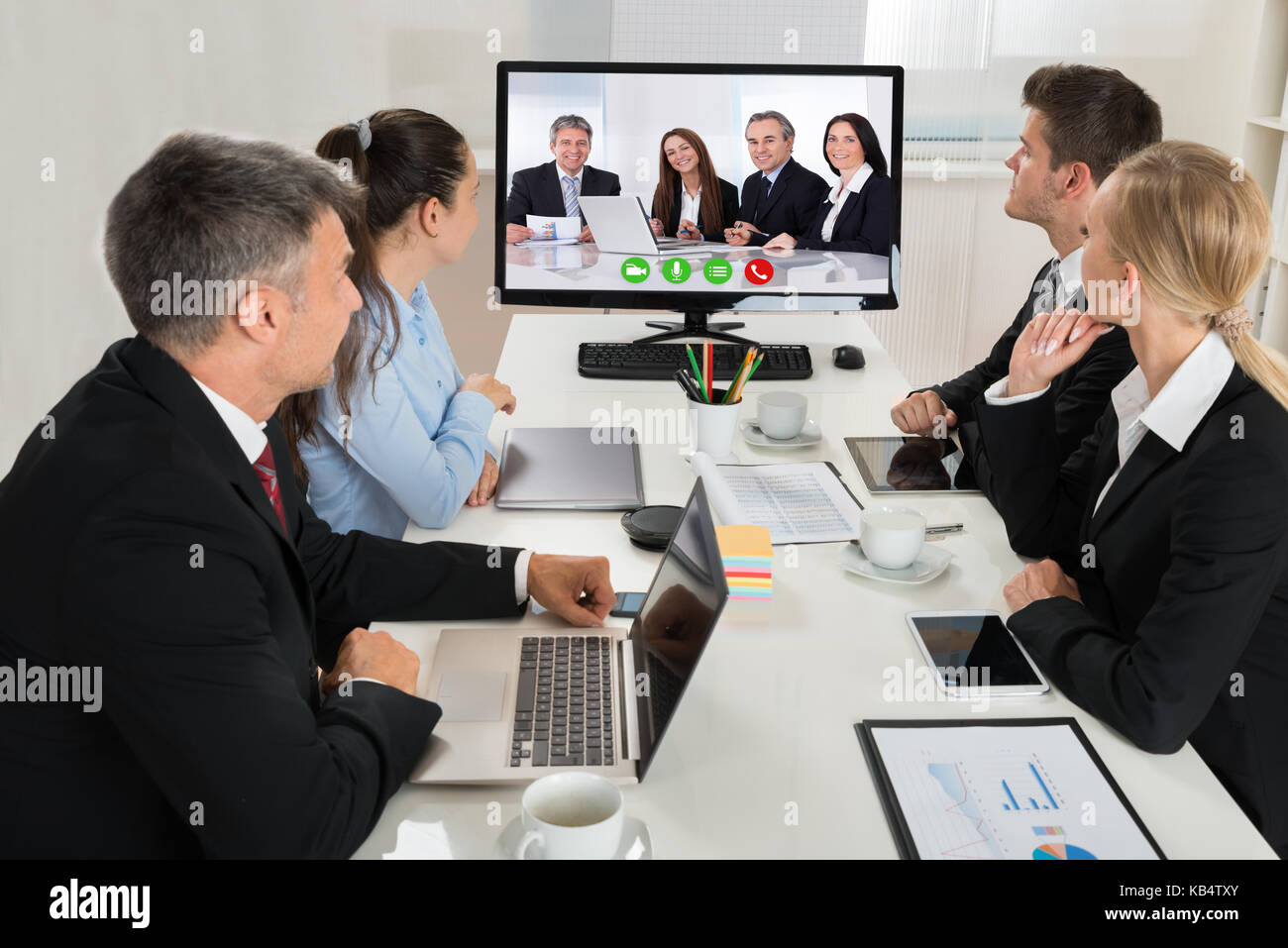 Group Of Businesspeople Watching An Online Presentation On A Desktop ...