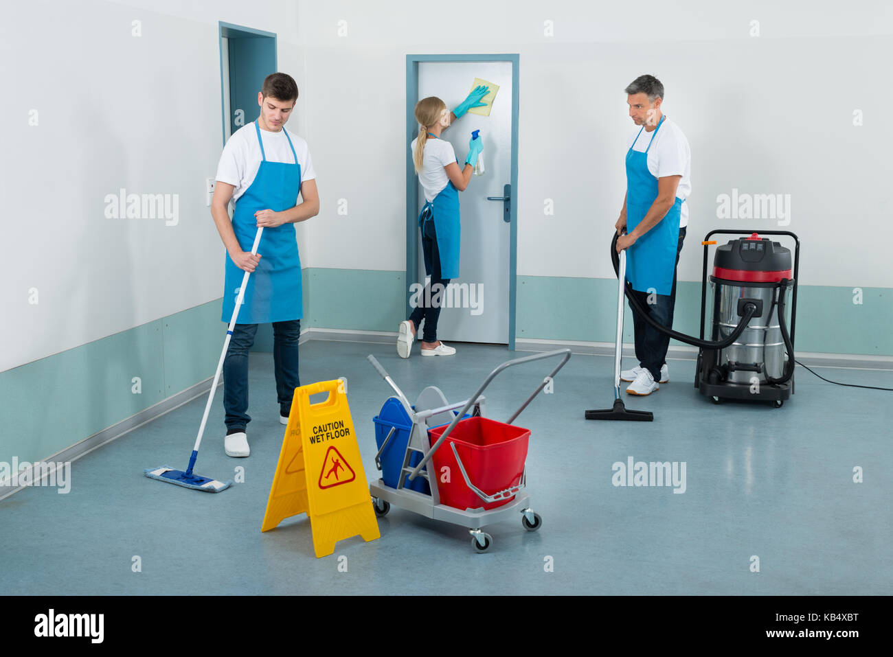 Group Of Janitors Cleaning Corridor With Cleaning Equipments Stock ...