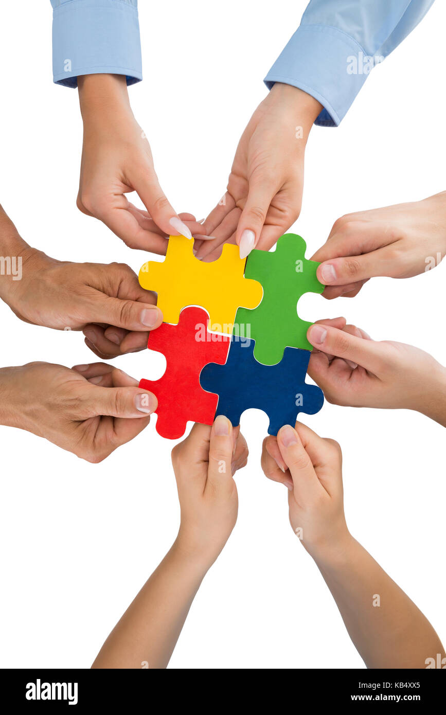 Close-up Of People Hands Holding Jigsaw Pieces Over White Background ...