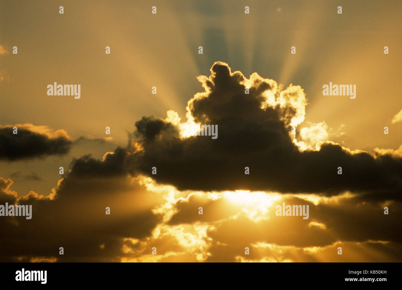 Sun rays beam from behind cumulus clouds Stock Photo - Alamy