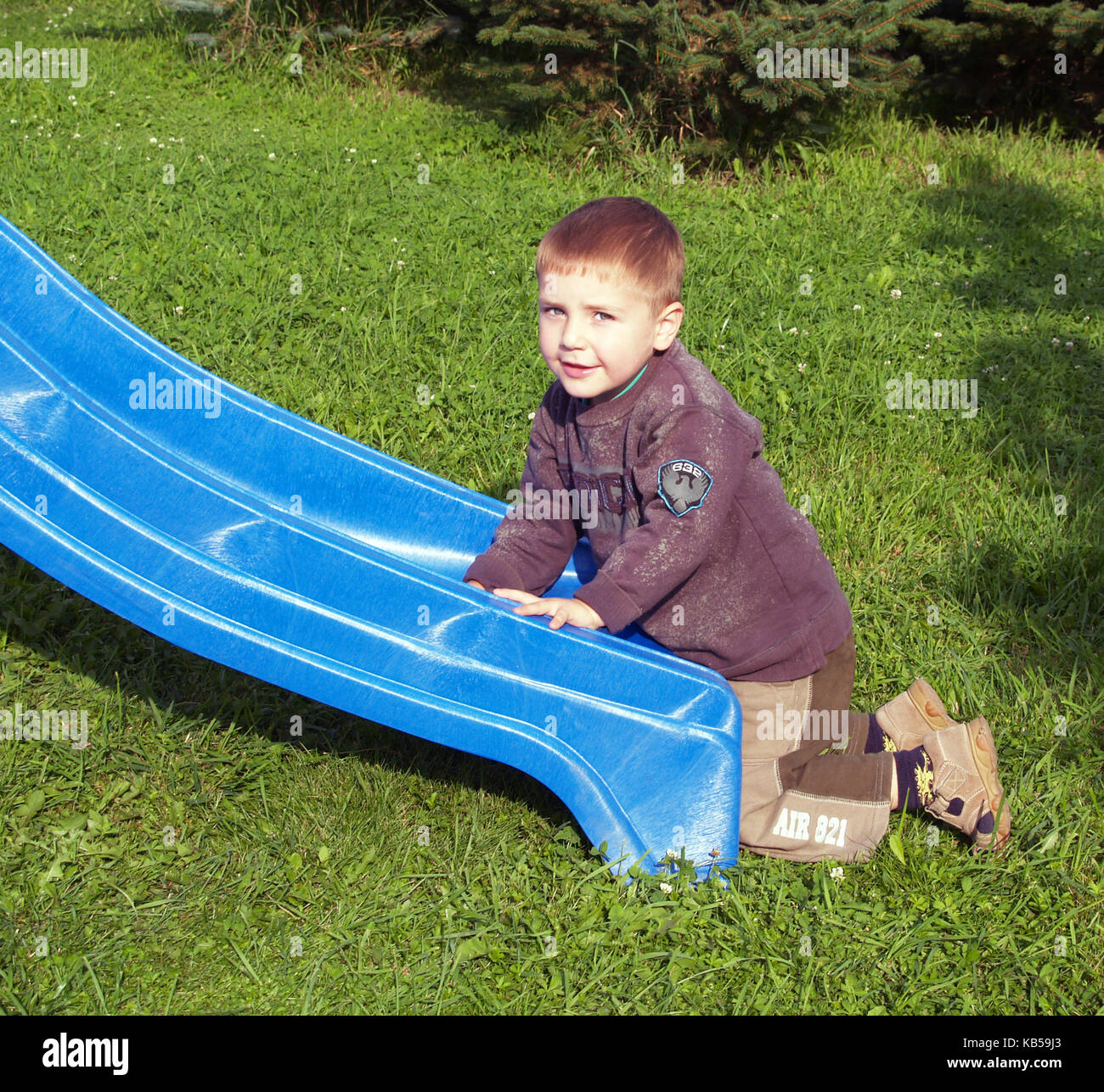 Little boy playing on chute Stock Photo - Alamy