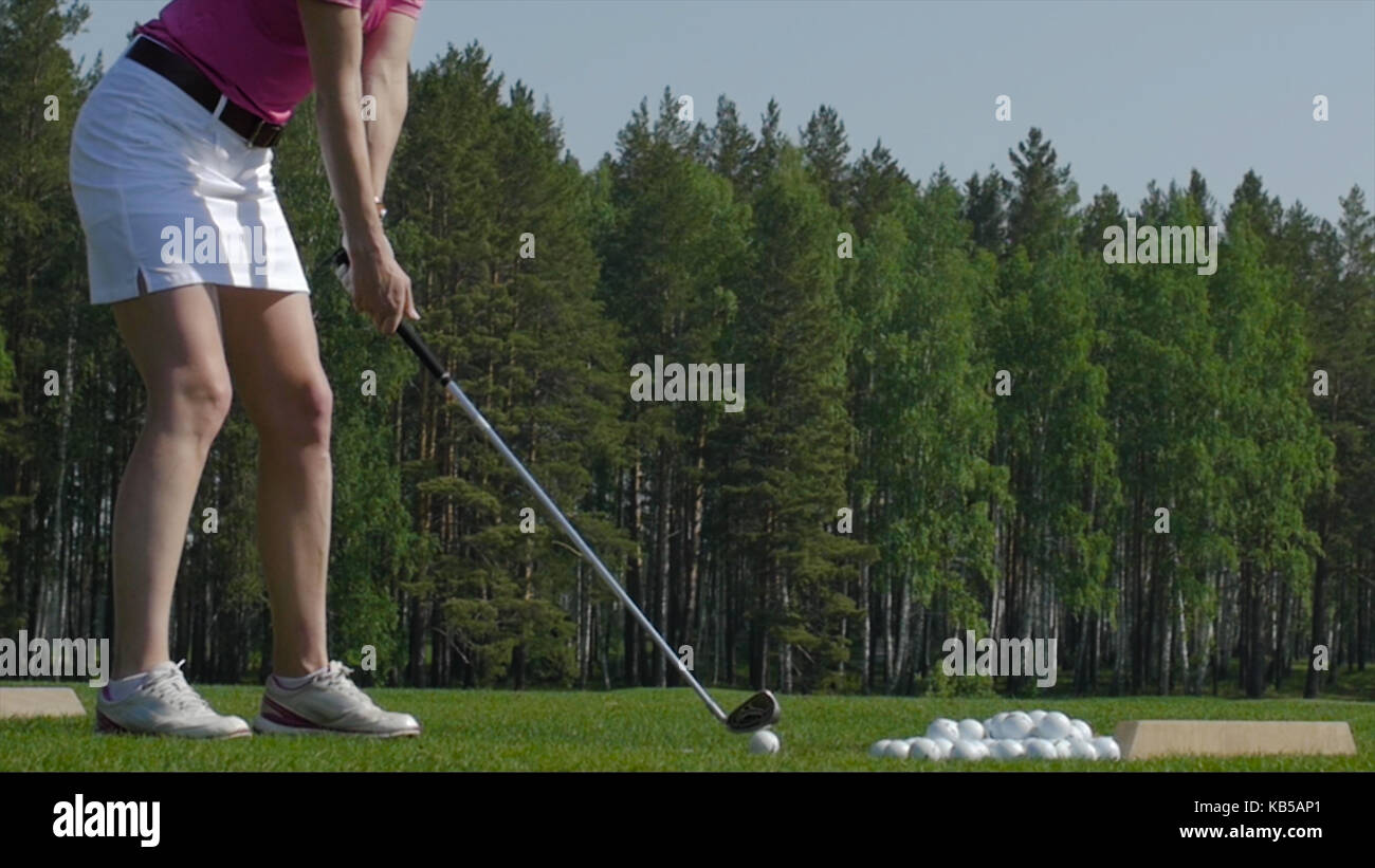 Golf player attempting the first stroke in the teeing area. Only legs ...