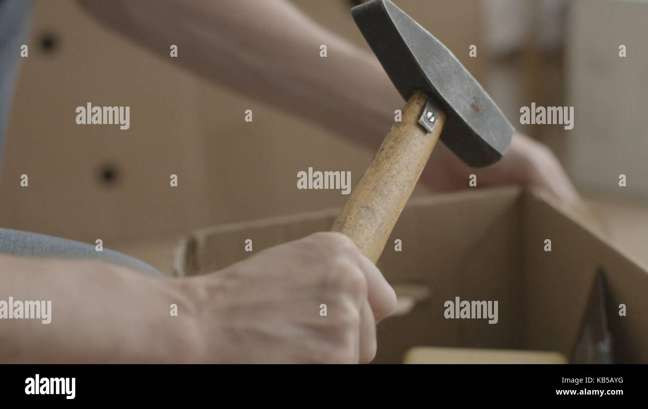 Man pulls a hammer out of the box. Man doing home renovations and pulls ...