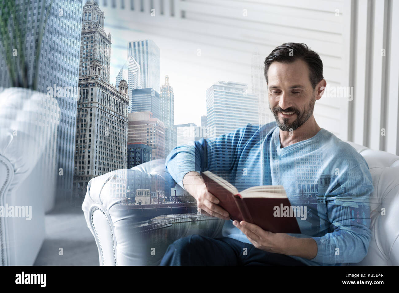 Positive man reading a book at home Stock Photo - Alamy