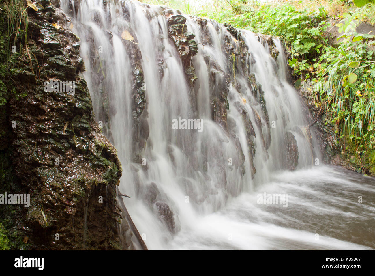 Stream blurred water in small waterfall Stock Photo - Alamy