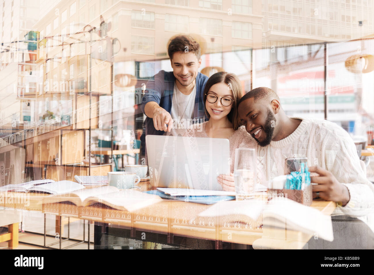 Cheerful friends looking at the screen with a huge interest Stock Photo ...