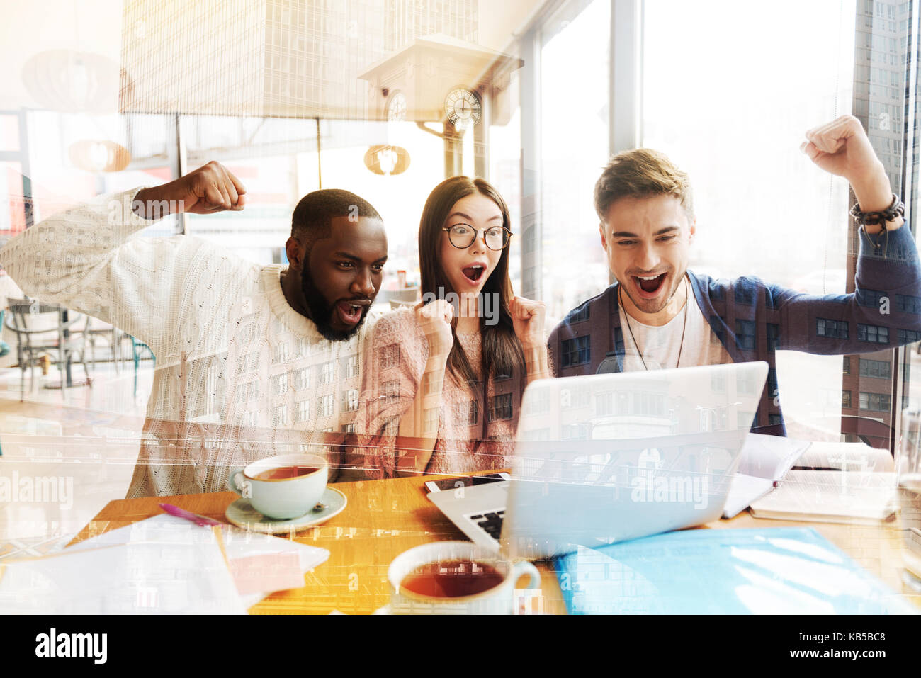 Optimistic students watching a football match Stock Photo - Alamy
