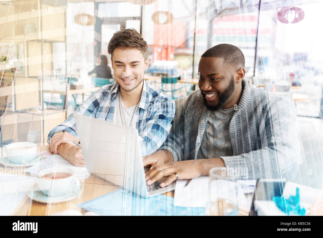 Smiling friends having rest in the cafe Stock Photo - Alamy