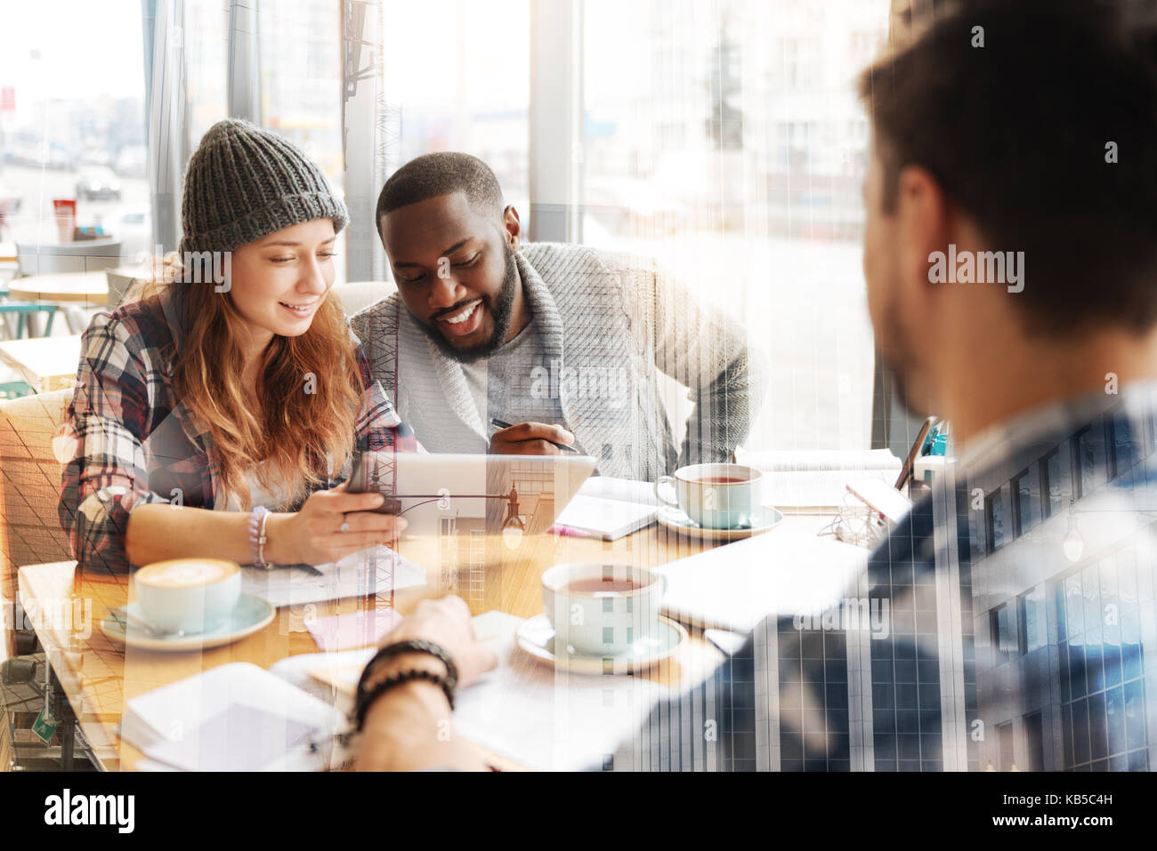 Smiling friends looking at the screen Stock Photo - Alamy