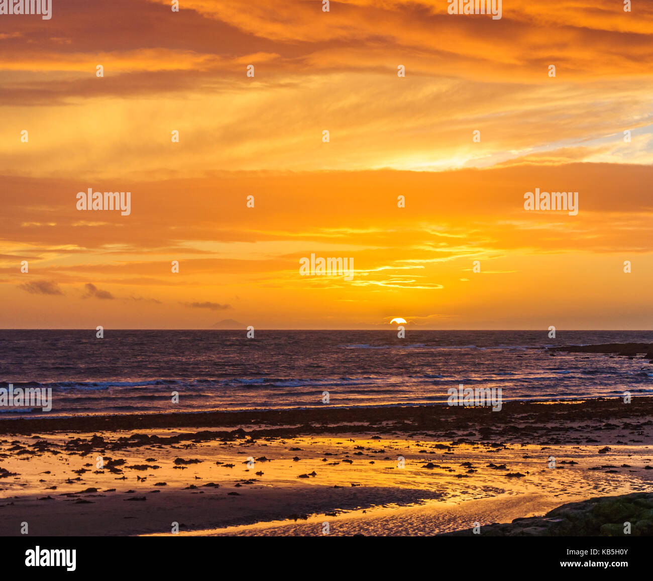 Sunset at Troon beach with the faint outline of Ailsa Craig on the ...