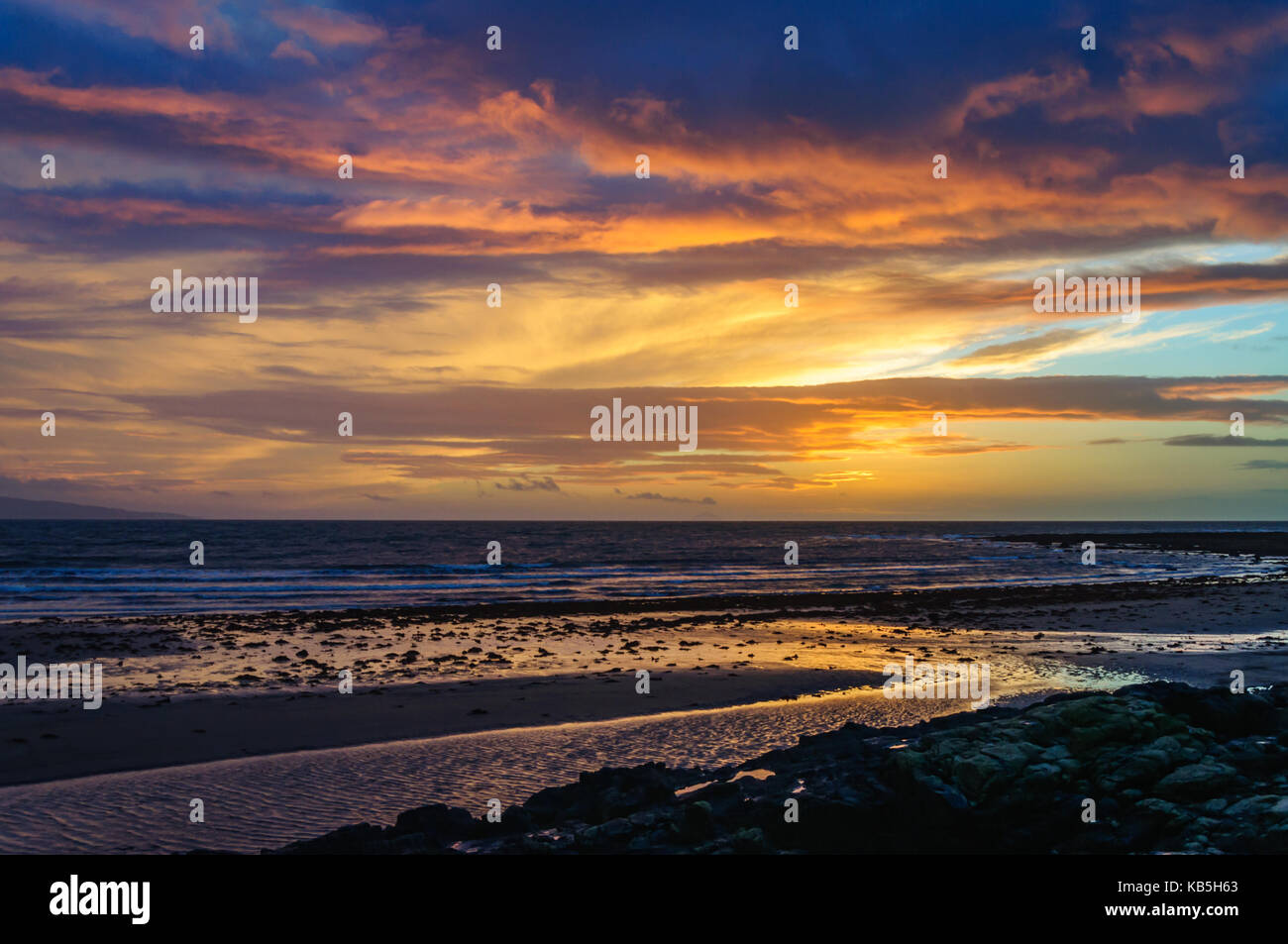 Sunset at Troon beach with the faint outline of Ailsa Craig on the ...